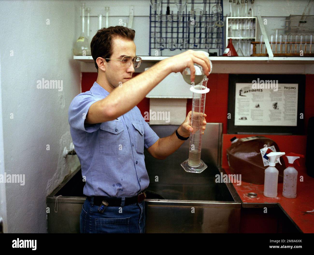 A photographer's mate conducts a chemical test for film processing at ...
