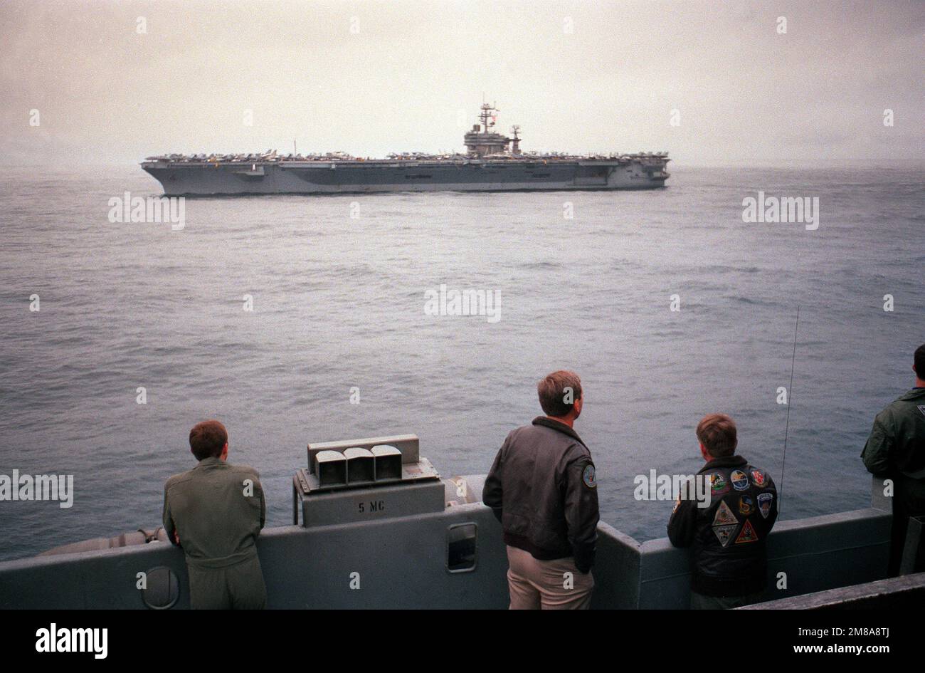 Crew members aboard the aircraft carrier USS FORRESTAL (CV-59) observe ...