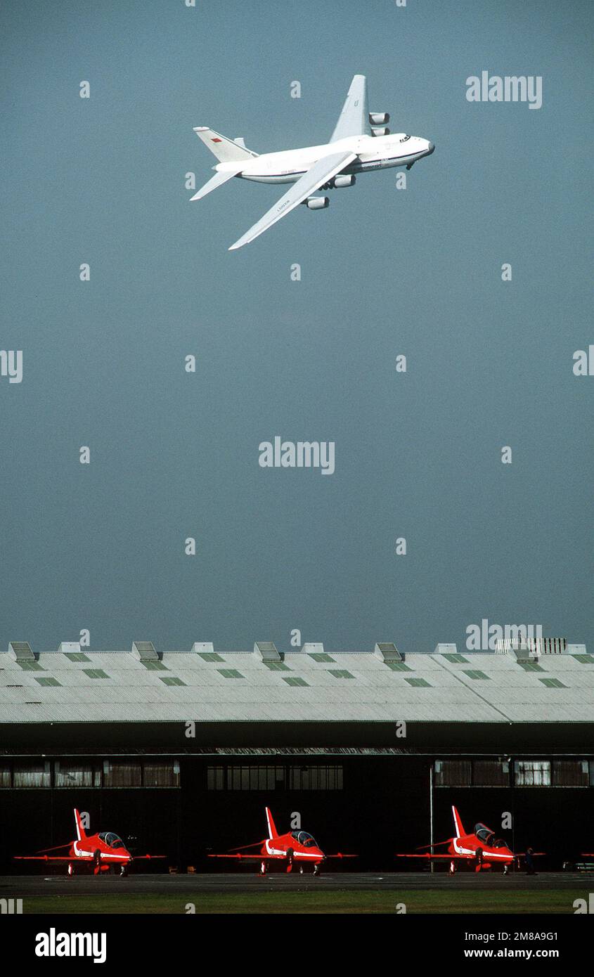 A Soviet An-124 Condor transport aircraft flies above a hangar ...
