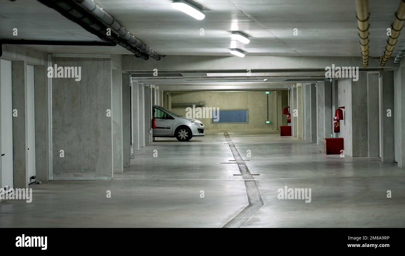 Car exiting underground building parking space in white grey vehicle ...
