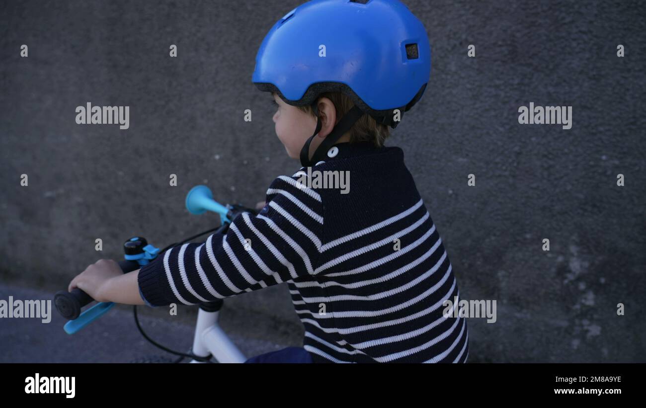 Child cyclist riding bike in city street outdoors. One active little ...