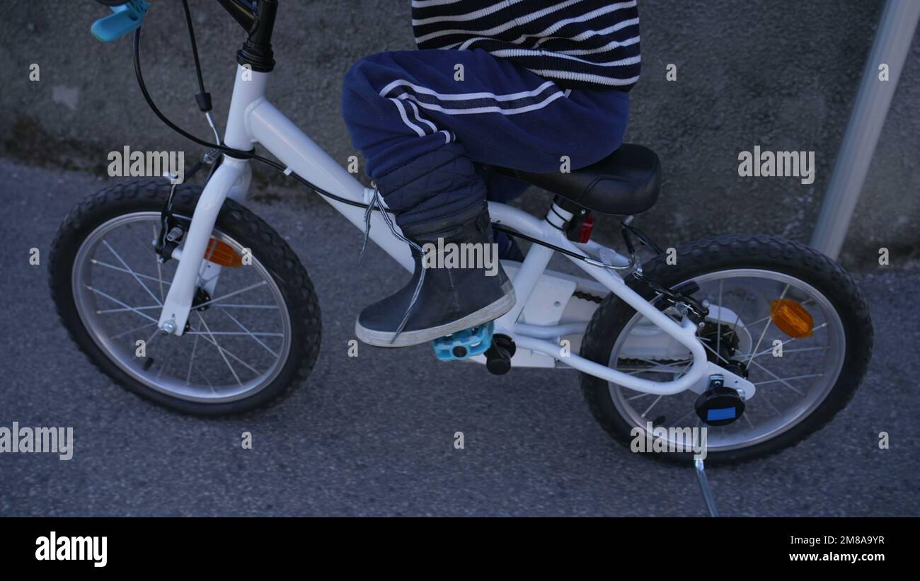 Child cyclist riding bike in city street outdoors. One active little ...