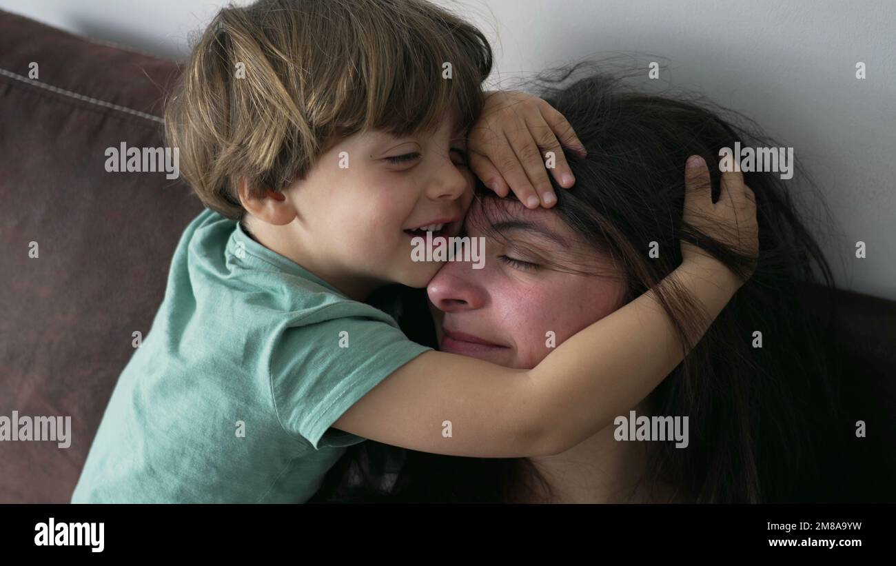 Child embracing mother. Candid little boy hugging mom head. kid ...