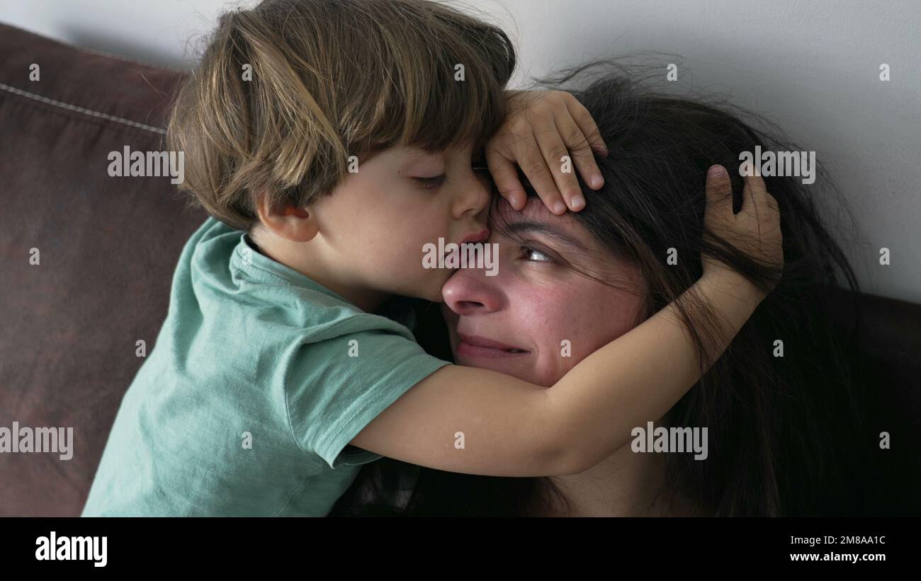 Child embracing mother. Candid little boy hugging mom head. kid ...