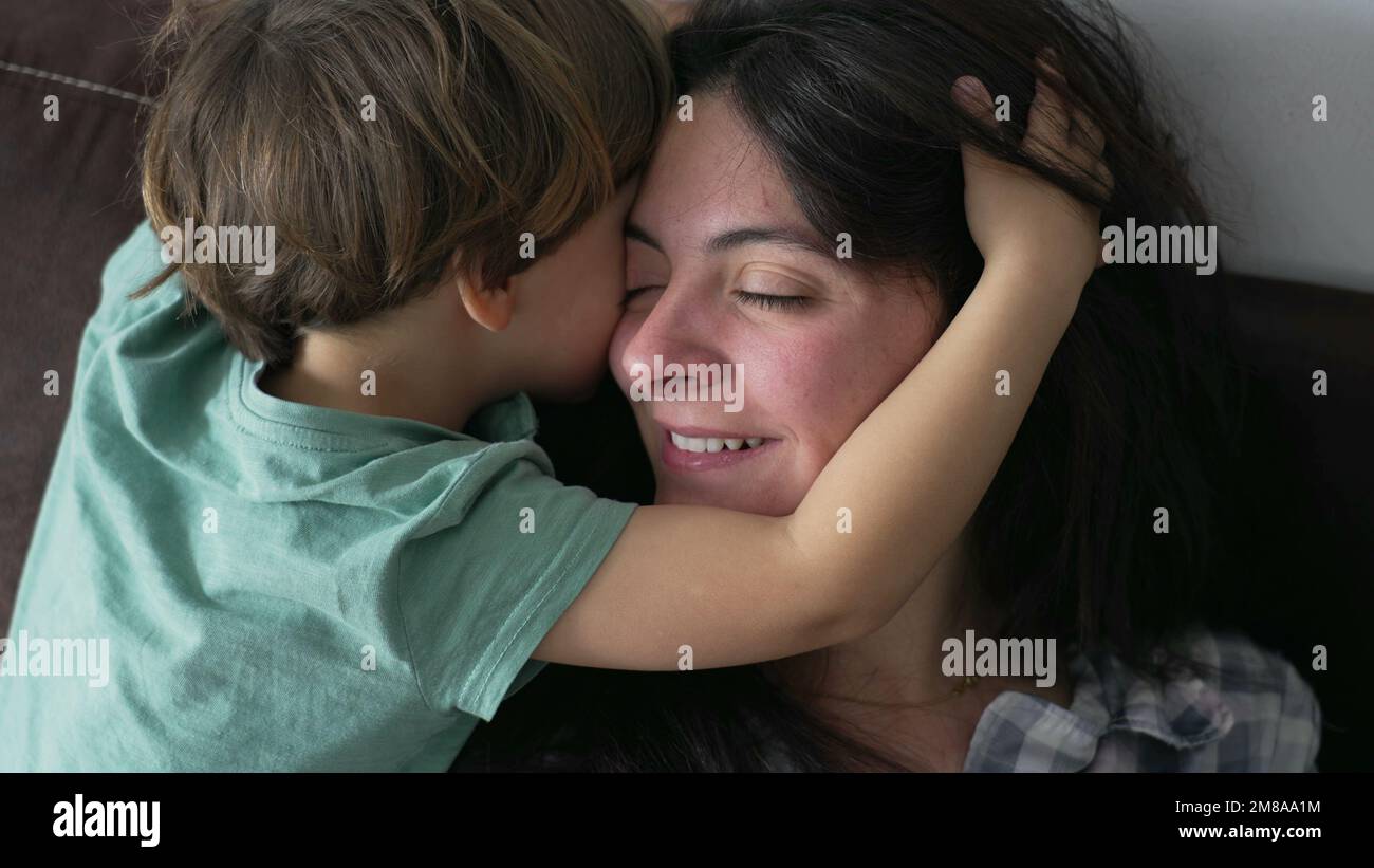 Child embracing mother. Candid little boy hugging mom head. kid ...