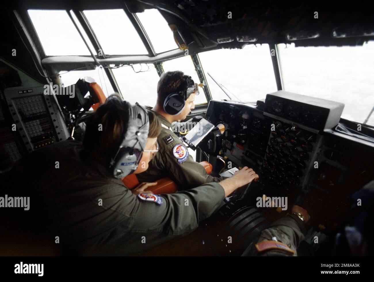 Inside the cockpit of a WC-130H Hercules aircraft, flight engineer TSGT ...