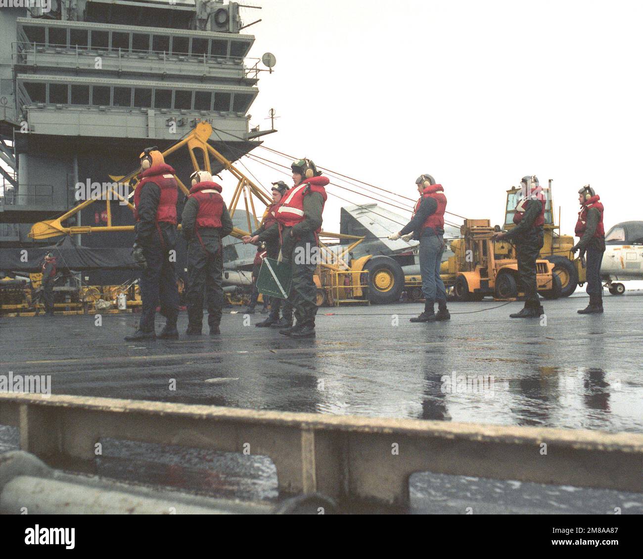 Line handlers stand on the flight deck of the aircraft carrier USS ...