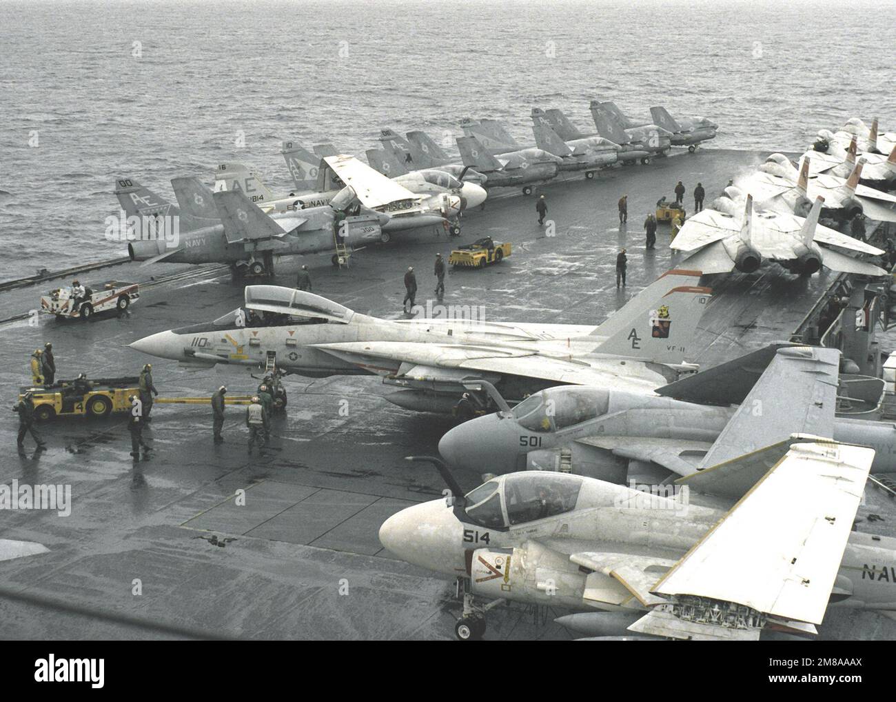 Aircraft handlers use an MD-3A tow tractor to respot an F-14A Tomcat ...