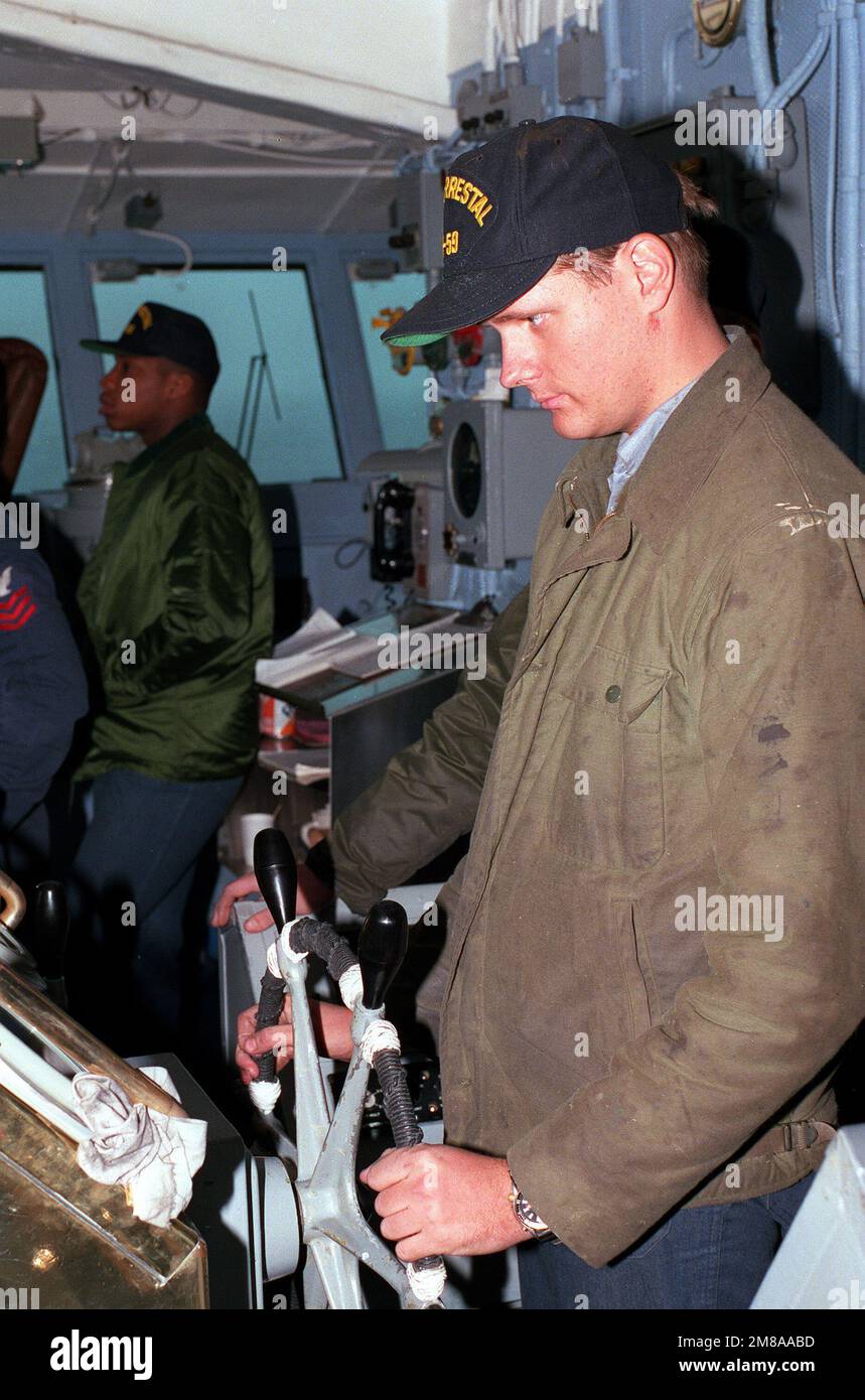 A boatswain's mate mans the helm on the bridge of the aircraft carrier ...
