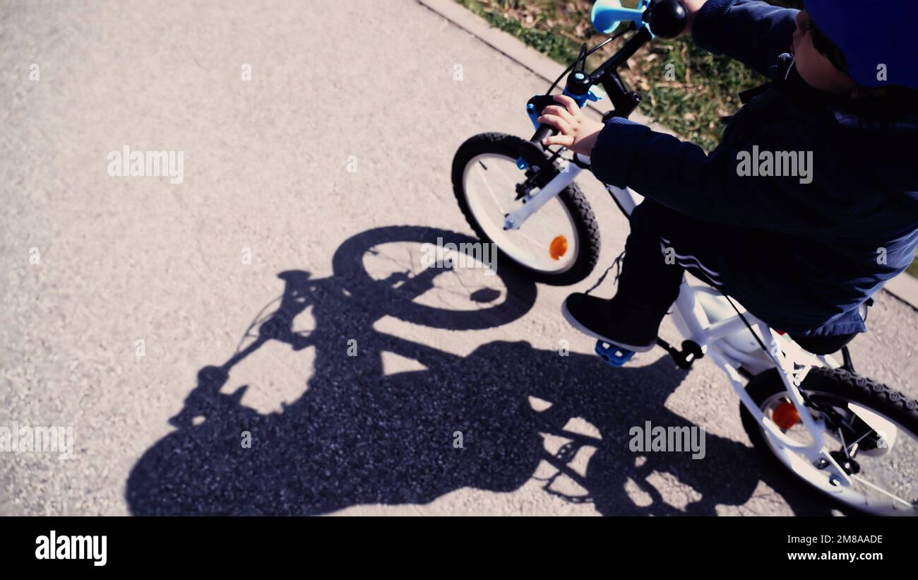 Child riding bicycle. Top view perspective of kid shadow outdoors Stock ...