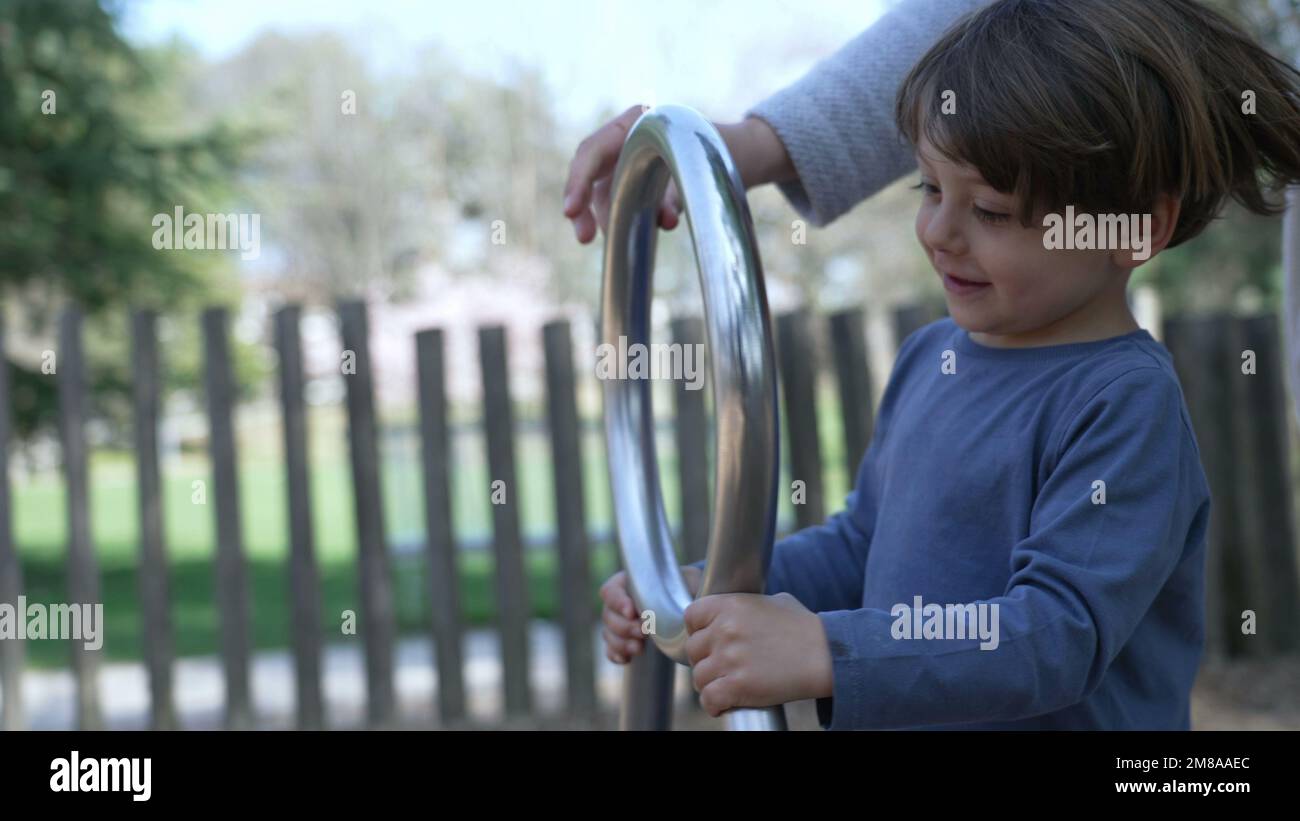 Child spinning at playground spinner structure. One little boy having ...