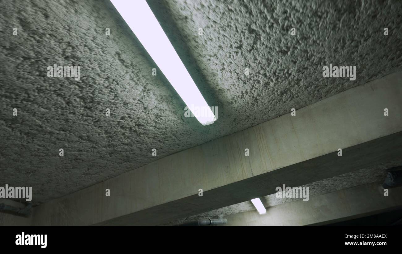 Underground garage florescent lights on concrete ceiling. Building ...