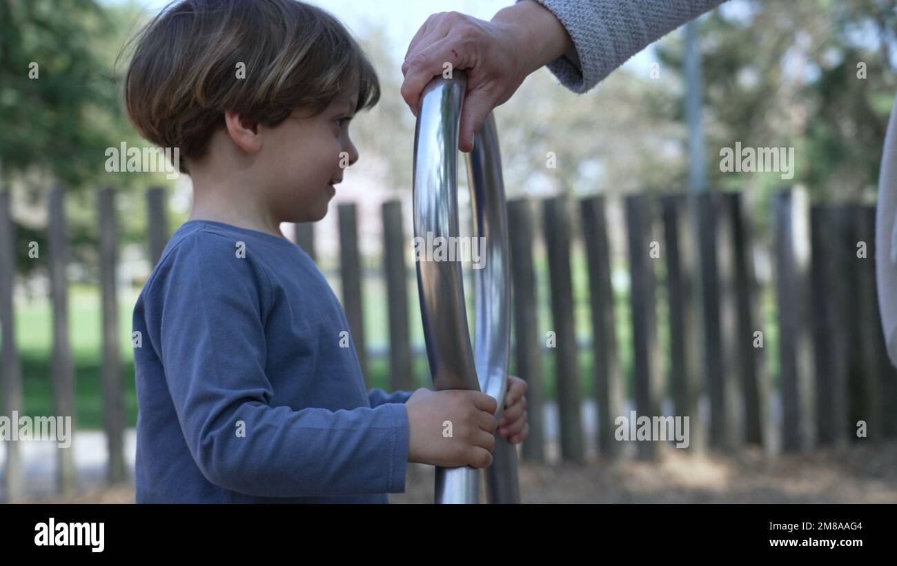 Child spinning at playground spinner structure. One little boy having ...