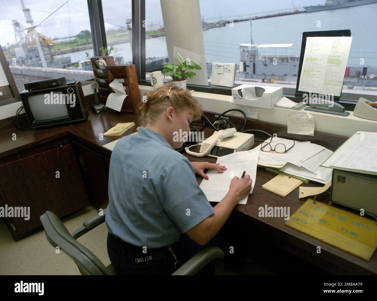 Electrician's Mate 2nd Class English checks over a port schedule at her ...