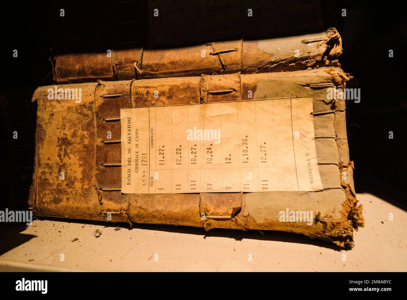 A view of the spine of a typical old, yellowed, sepia bank ledger book ...
