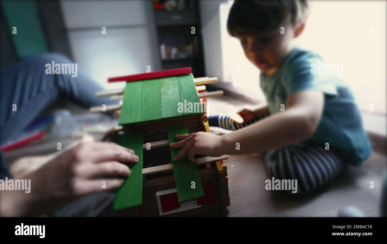 Child building wooden house toy in playroom. One little boy putting ...