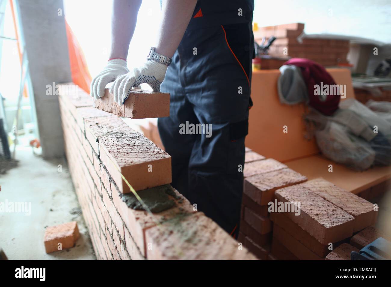 Construction mason builds brick wall in apartment Stock Photo - Alamy