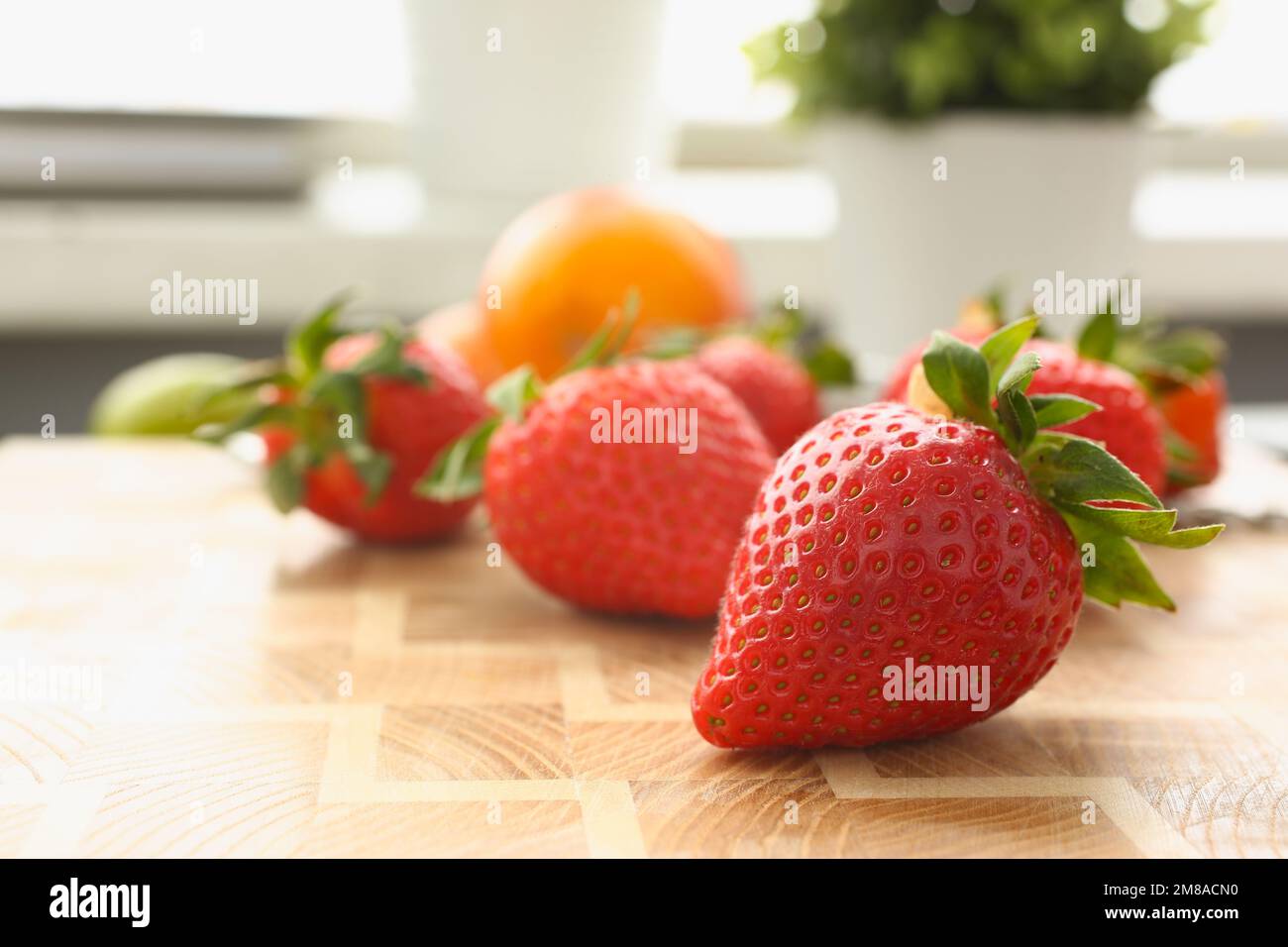 Fresh juicy strawberries and fruits on board Stock Photo - Alamy