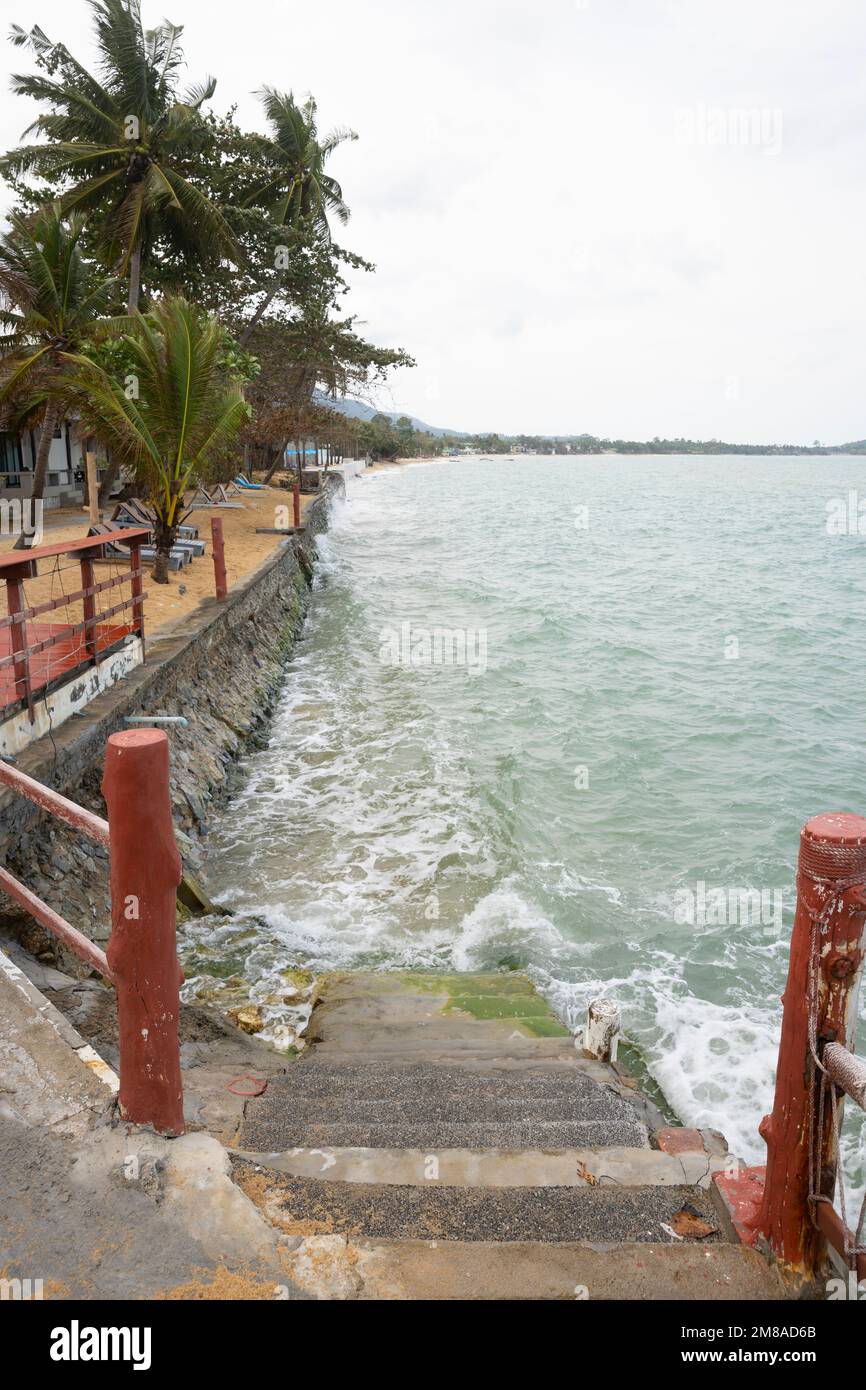 Steps to the sea at high tide with very little beach in strong wind and ...