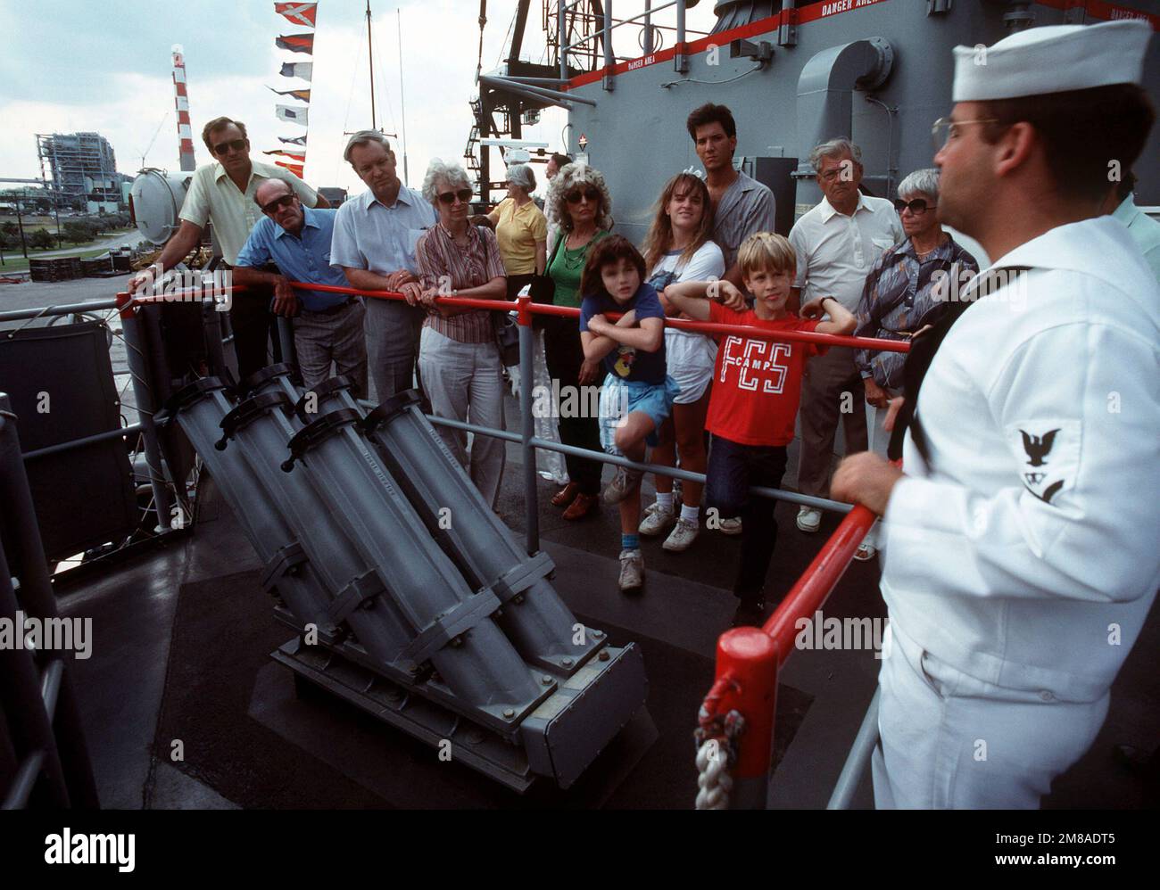 A sailor briefs visitors on chaff launchers aboard the guided missile ...