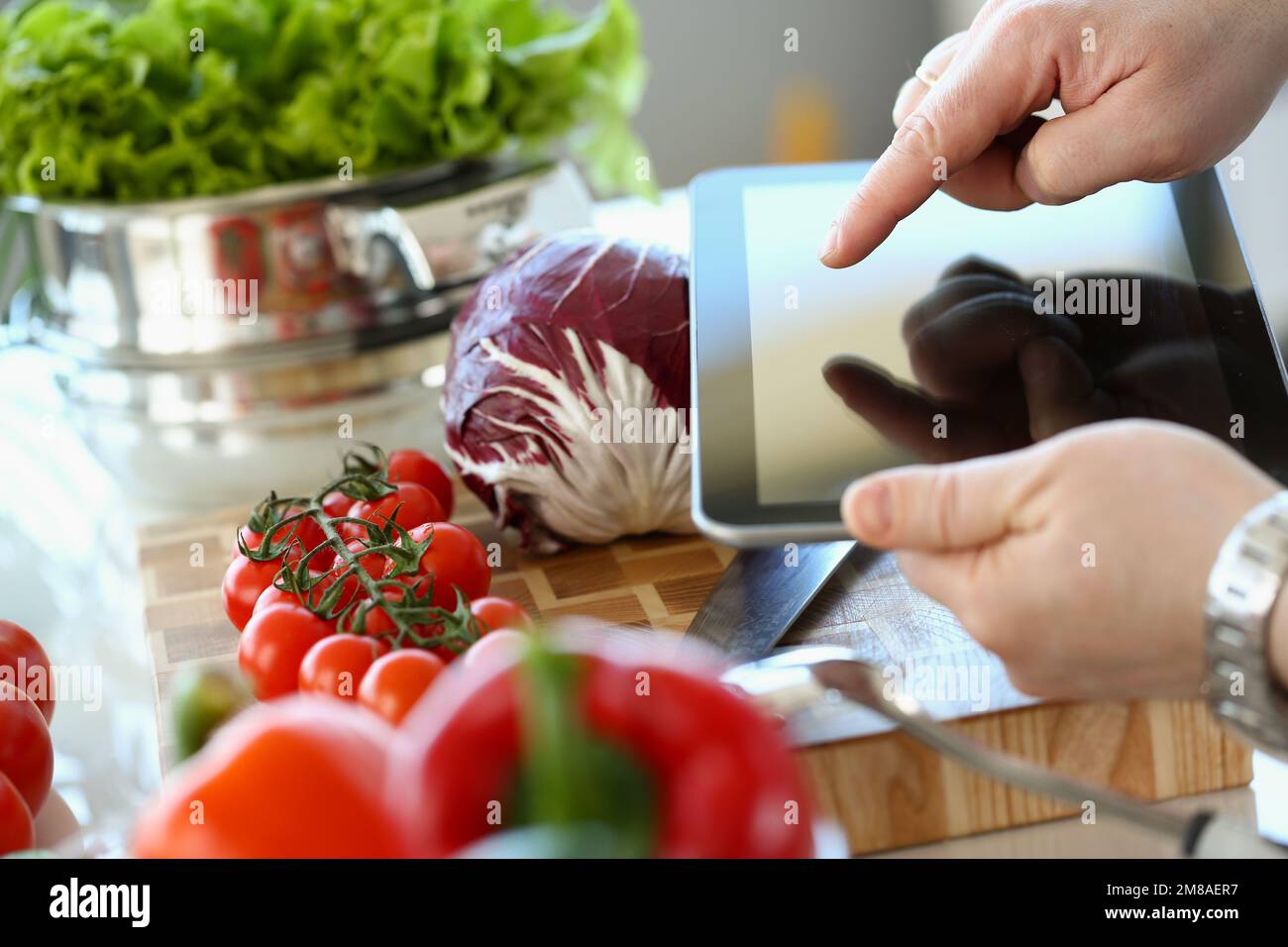 Person holds tablet and is going to cook vegetables Stock Photo - Alamy