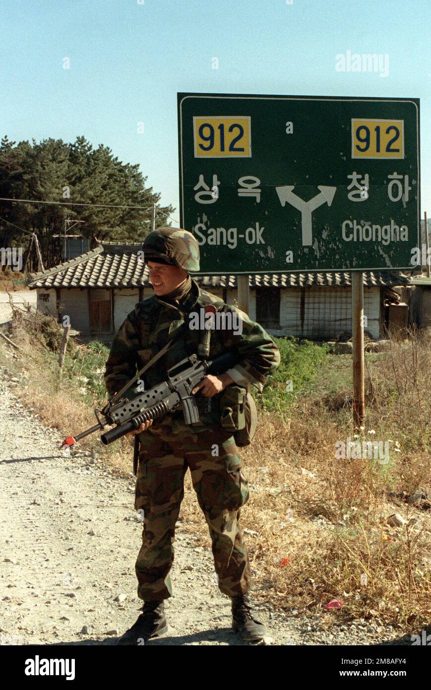 A Marine armed with an M-16 rifle equipped with an M-203 grenade ...