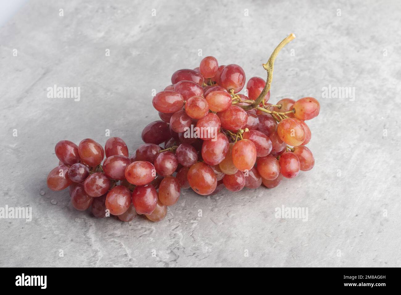 fresh red grapes on a gray background Stock Photo - Alamy