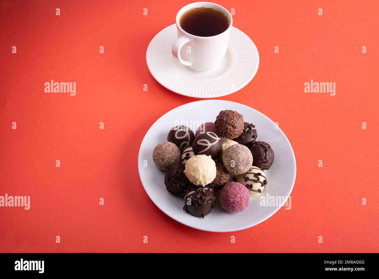 photo multicolored sweets on a white round plate next to a cup with a ...