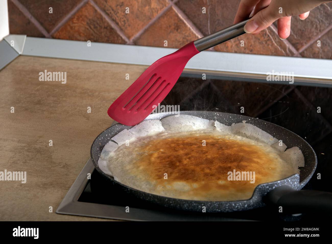photo of a fried pancake lying in a pan on the stove Stock Photo - Alamy