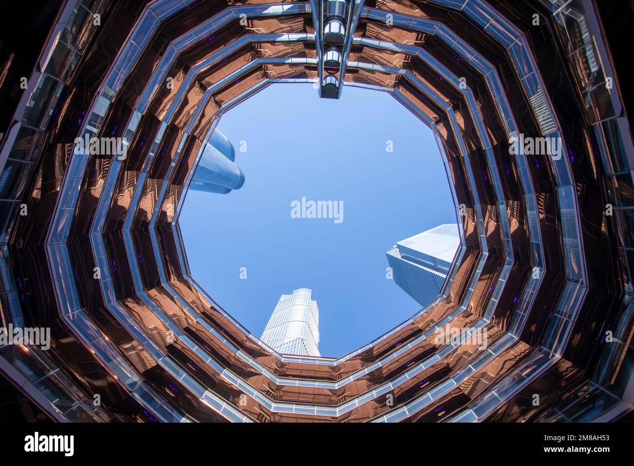 A low angle of a spiral modern urban building under sunny blue sky in ...