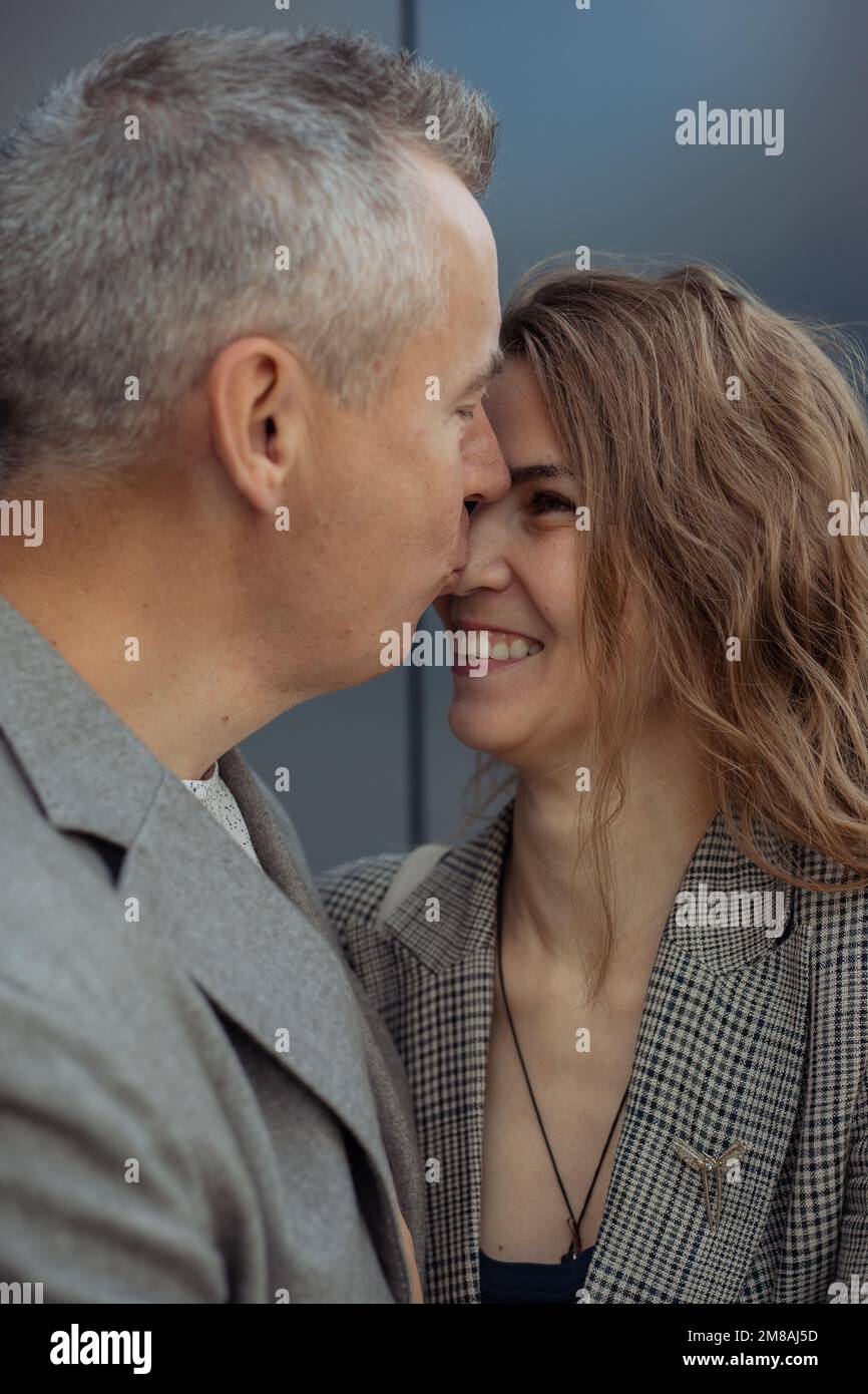 Vertical romantic couple of mature gray haired man kissing to nose fair ...