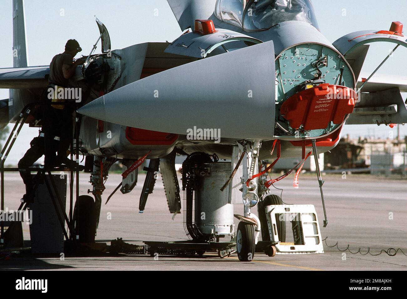 Its nose section swung open, an F-15 Eagle aircraft is served on the ...
