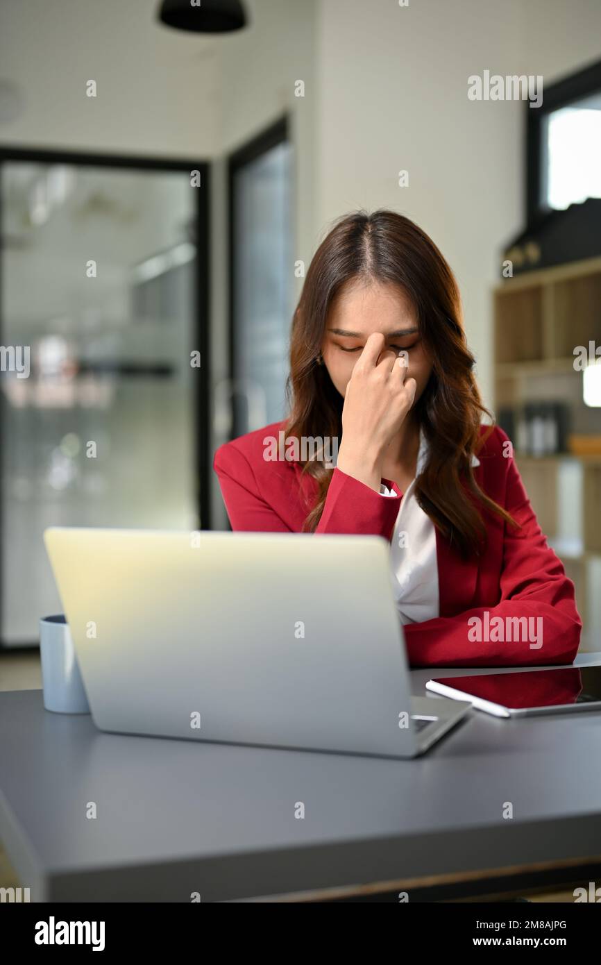 Portrait, Stressed and depressed millennial Asian businesswoman sits at ...