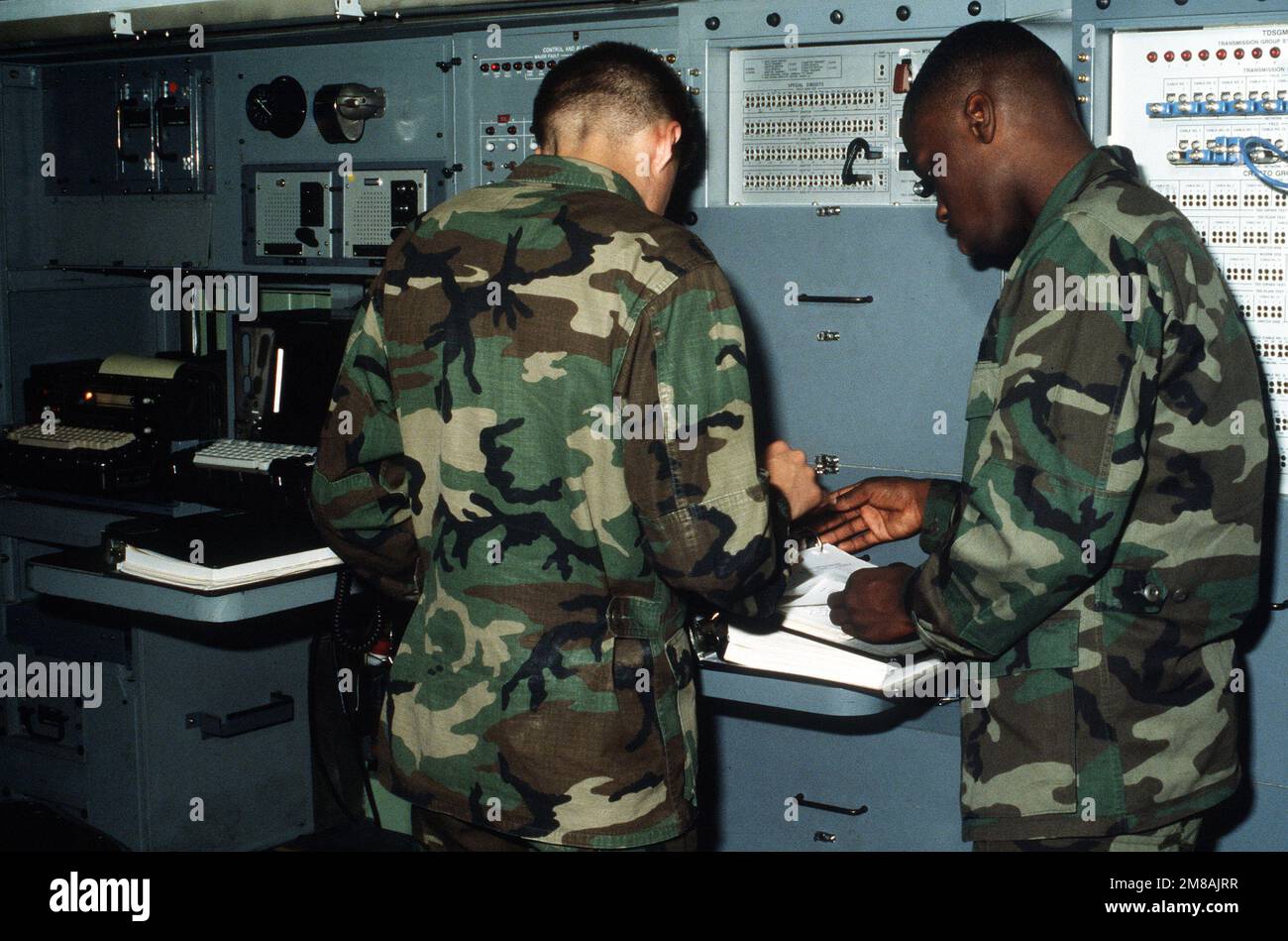 Two students at the US Army Signal School check a reference binder ...