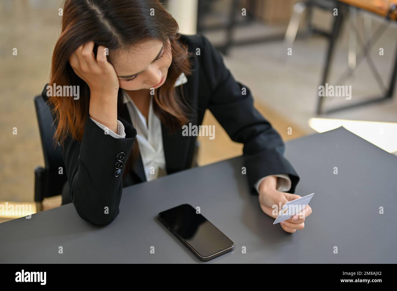 Stressed and unhappy Asian female office employee is having financial ...