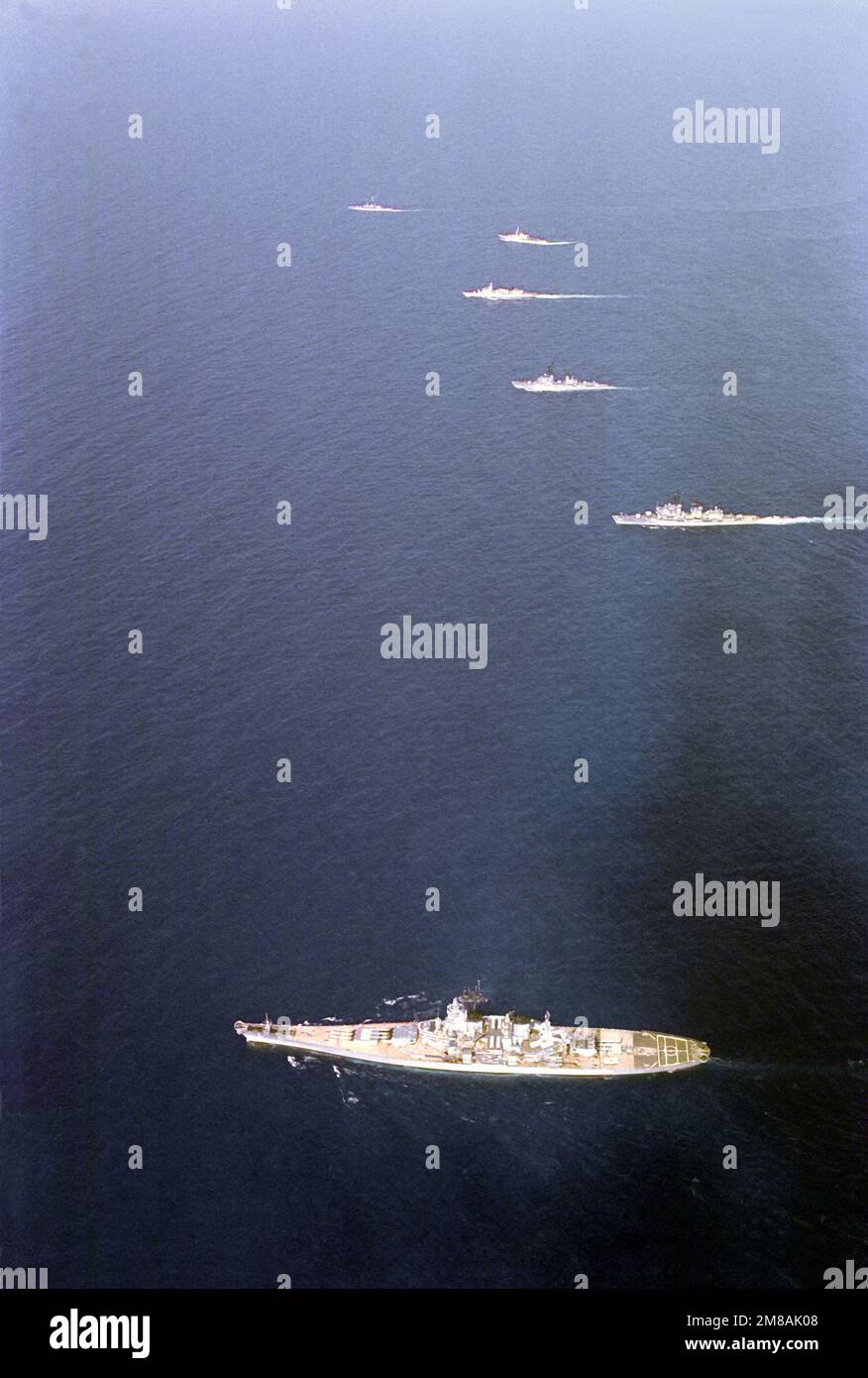 An aerial port beam view of the battleship USS IOWA (BB-61) underway with other vessels of a ...