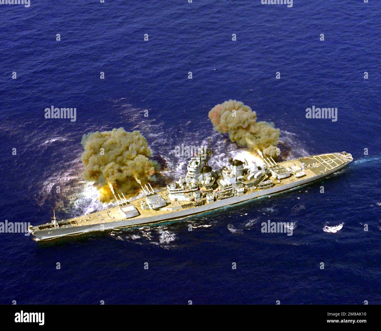 An aerial view of the battleship USS IOWA (BB-61) firing its Mark 7 16 ...