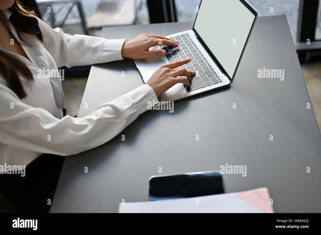 Concentrated Asian businesswoman using laptop computer, typing in ...