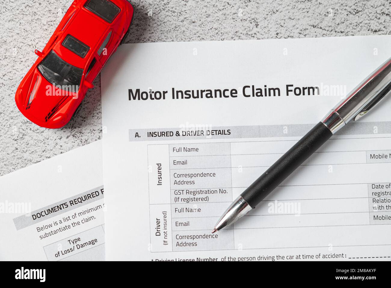 Motor or car insurance claim form with ballpoint pen and car model ...