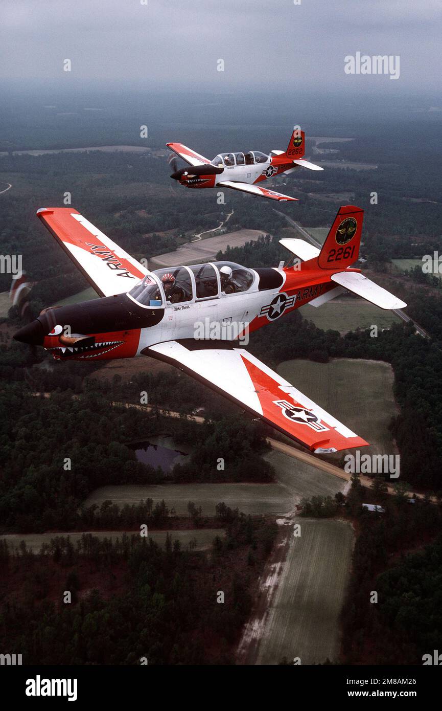 An air-to-air left front view of two T-34C Mentor aircraft flying in formation. The aircraft are ...
