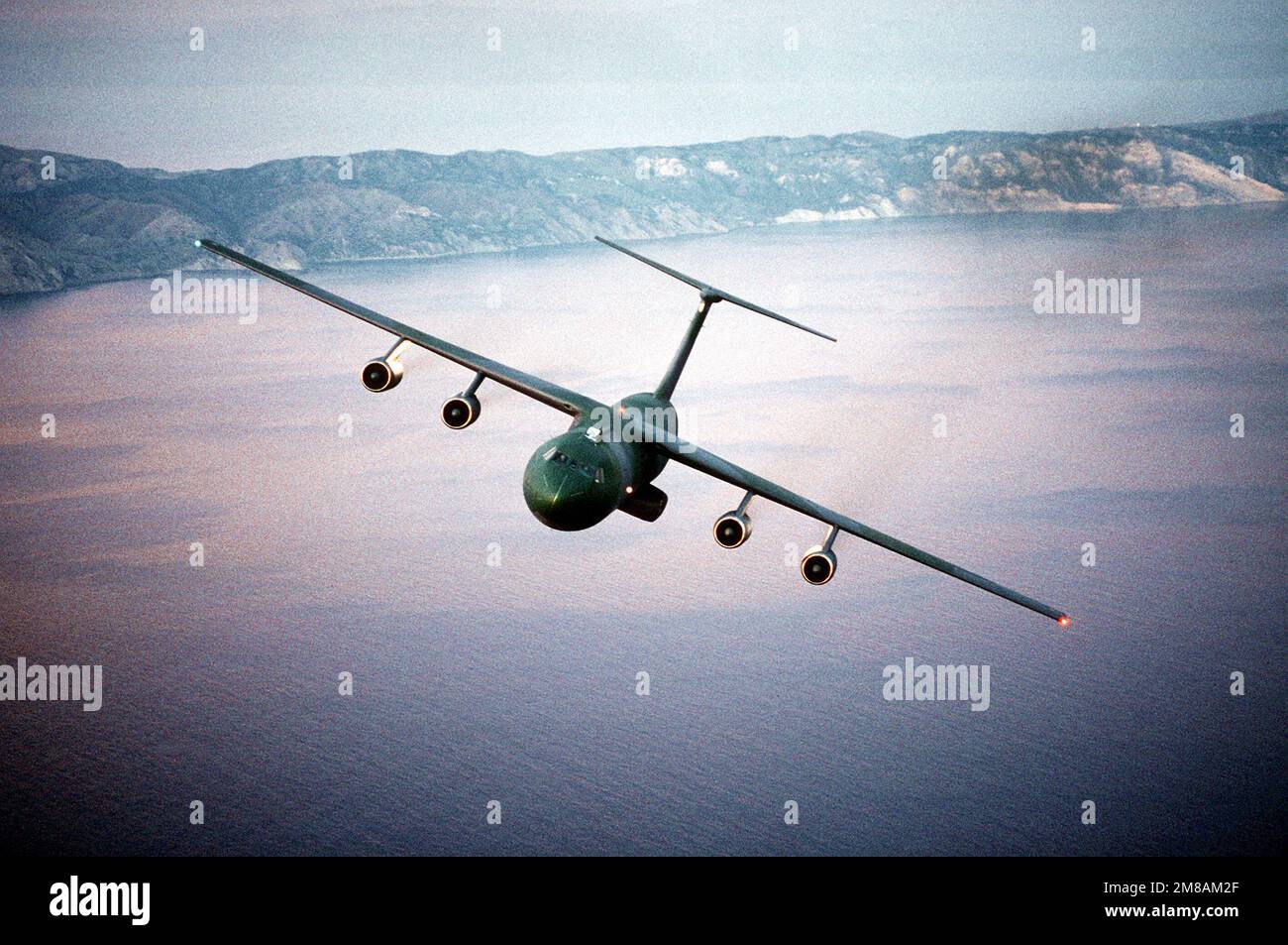 An air-to-air front view of a C-141B Starlifter aircraft in flight. The ...
