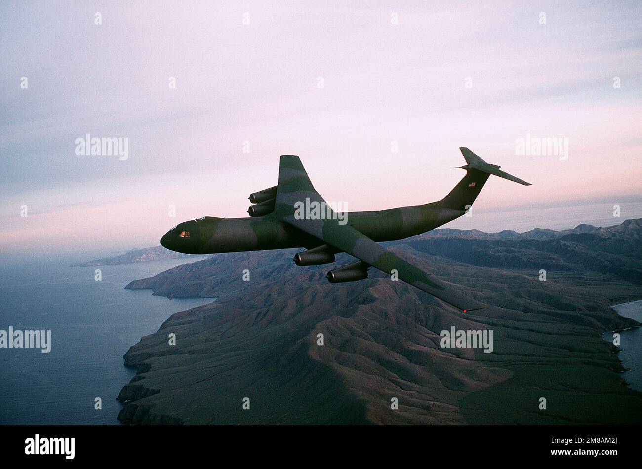 An air-to-air left side view of a C-141B Starlifter aircraft in-flight ...