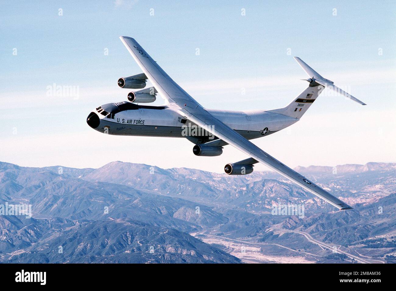 An air-to-air left front view of a C-141B Starlifter aircraft banking ...