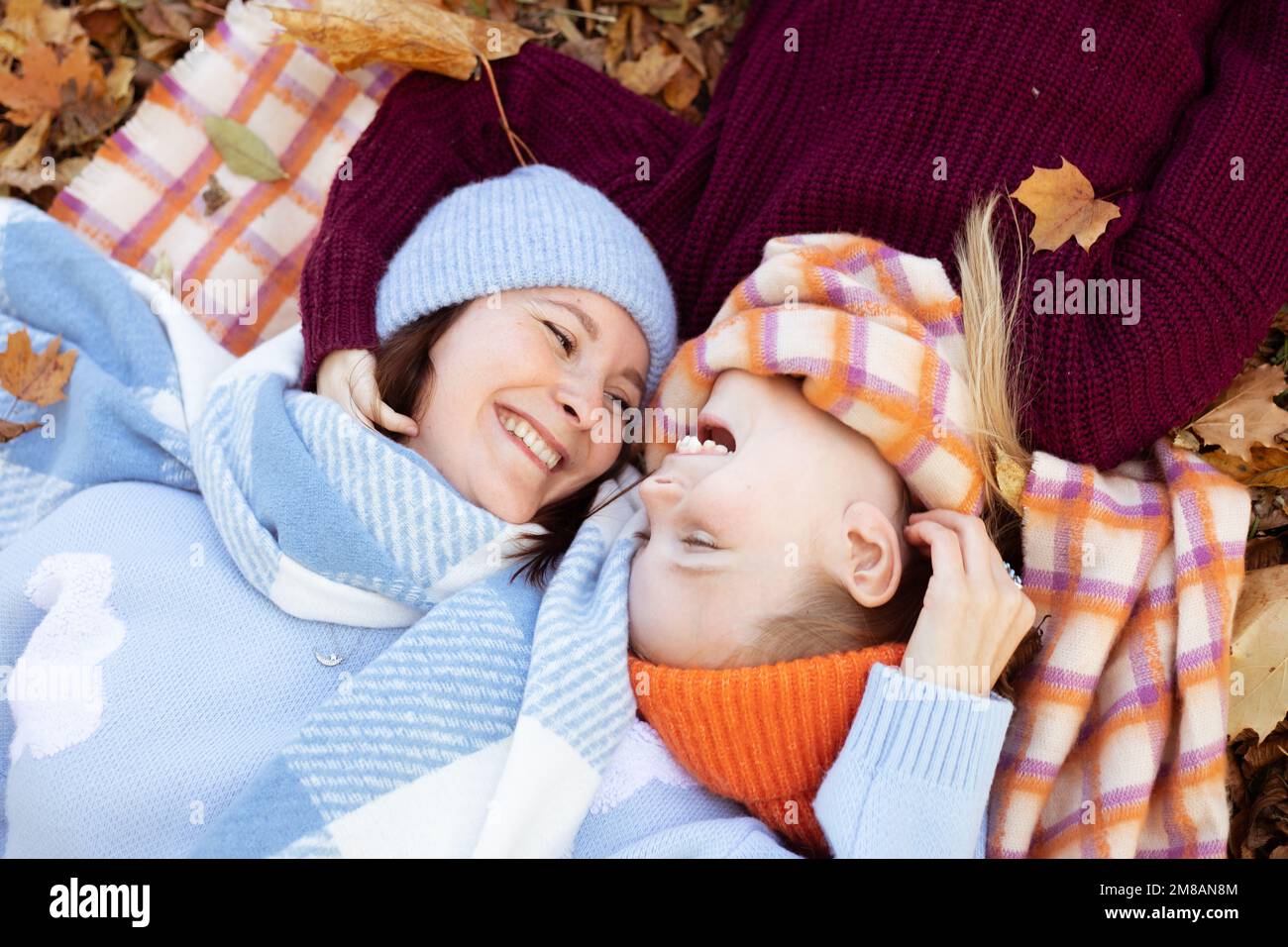 Top view of laughing family of young woman, teenage girl hugging, lying ...
