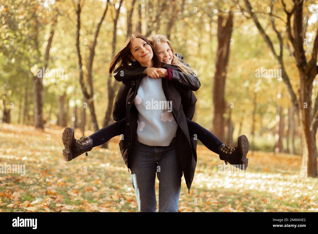 Portrait of family of young woman and teenage girl walking in forest ...