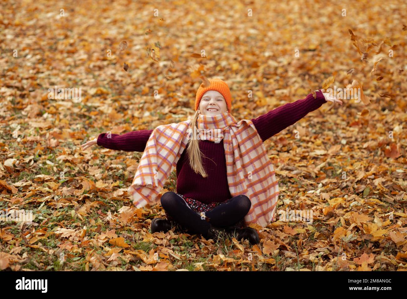 Happy teenage girl child wearing vinous sweater, orange hat, checkered ...