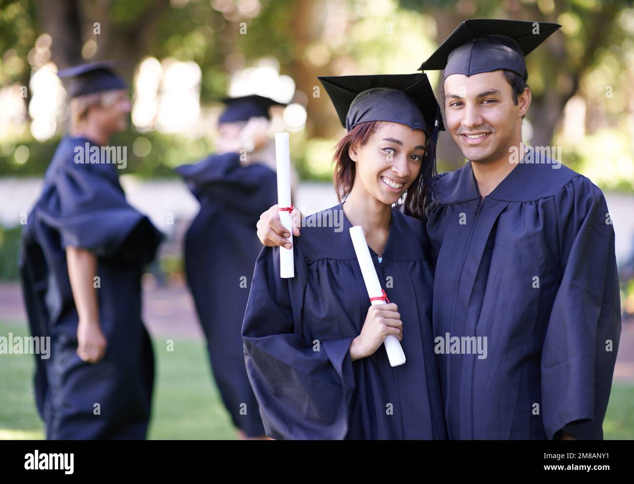 Graduating together. Portrait of a smiling graduate couple holding ...