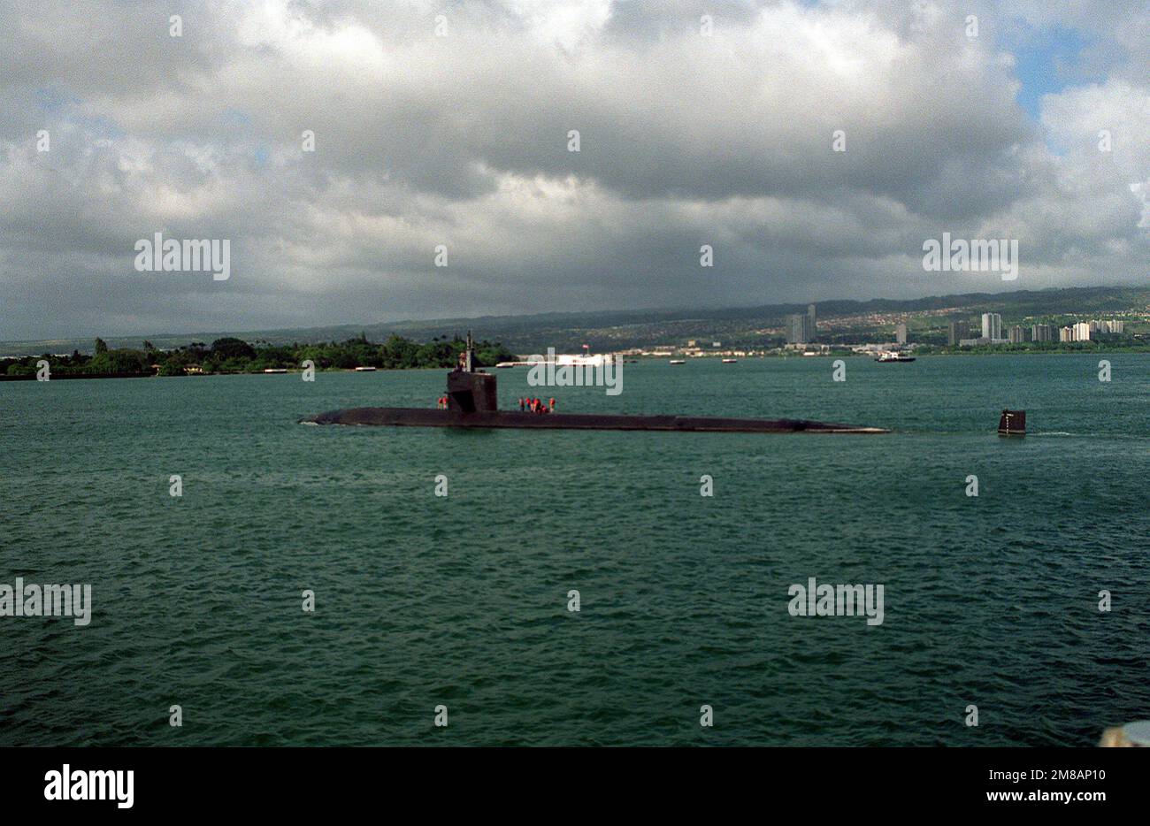 Crew members stand on the deck of the nuclear-powered attack submarine ...