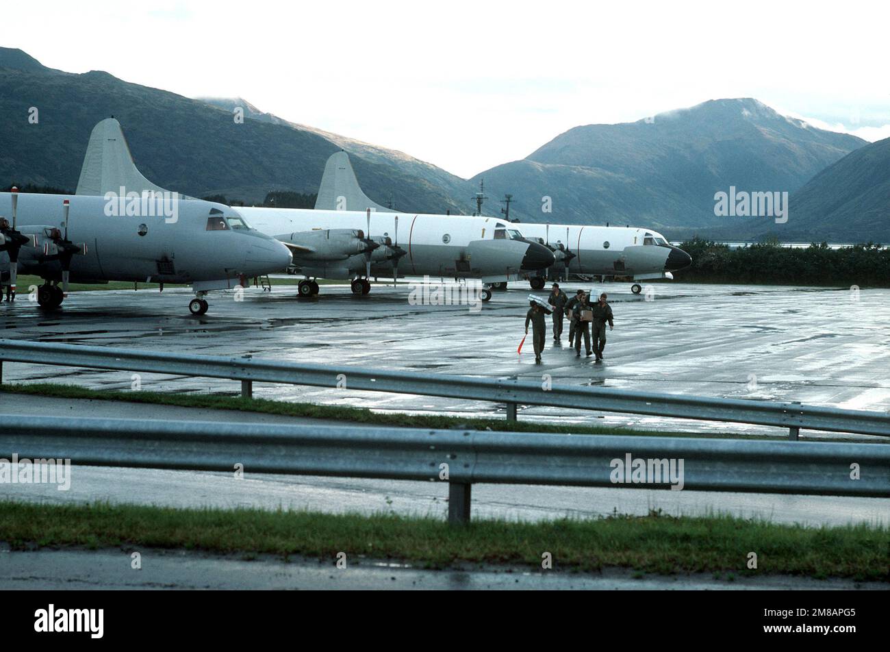 Air crew members walk off the flight line in front of a group of P-3C ...