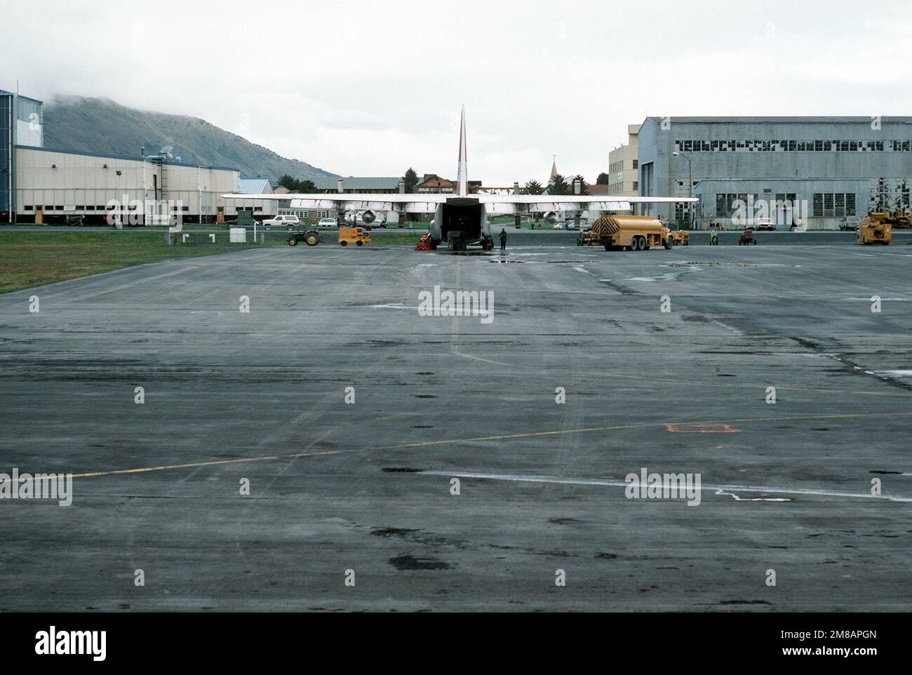 A C-130 Hercules aircraft is loaded on the flight line during PACEX '89 ...